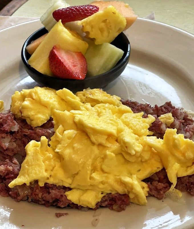 When corned beef hash meets scrambled eggs with a side of fresh fruit, it's like the breakfast gods decided you deserve something special today.