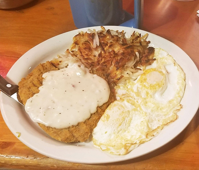 Country fried steak with eggs and hash browns: because sometimes you need breakfast that actually respects you.