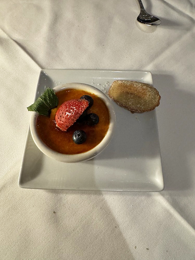 Cr&egrave;me br&ucirc;l&eacute;e with a perfectly shattered sugar ceiling and a madeleine sidekick&mdash;dessert diplomacy at its finest.