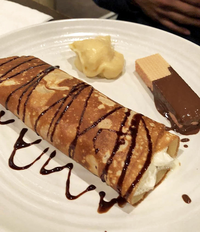 Not just any dessert, but a chocolate-drizzled crepe filled with sweet cream. The kind of finale that makes you forget you promised yourself "just one plate."