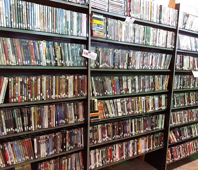 A cinephile's dream wall. Before streaming services, these plastic cases held the gateway to movie night magic.