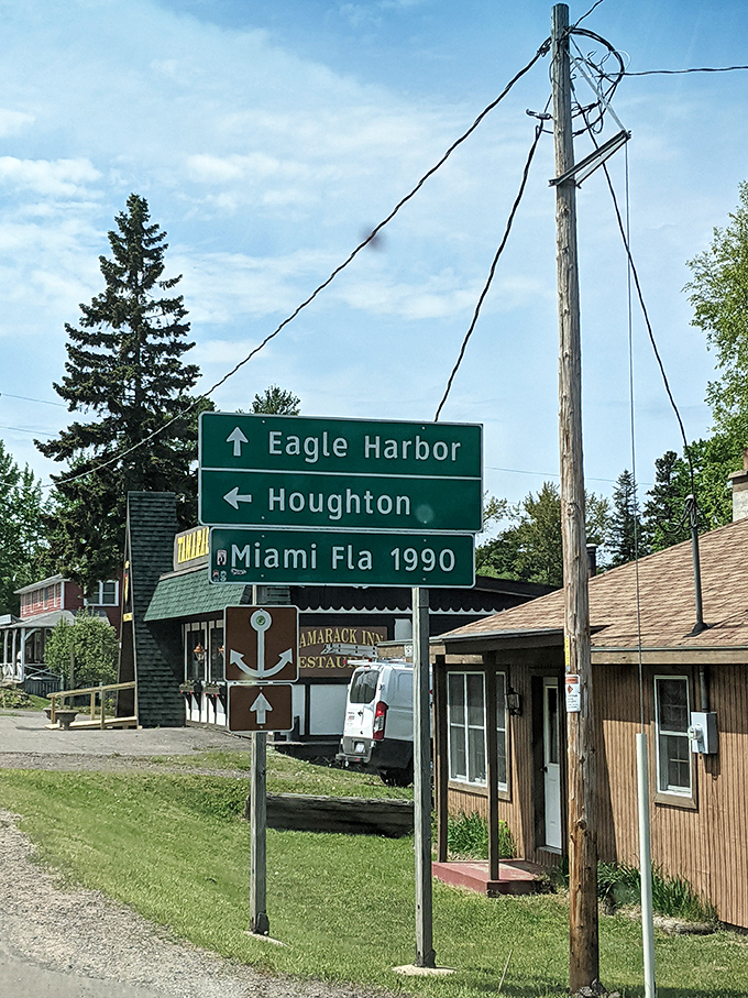 That sign says Miami is 1990 miles away—and about a million lifestyle degrees different. Copper Harbor's version of a traffic jam is two cars at this intersection.