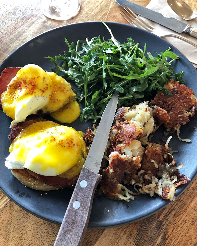 Eggs Benedict that would make a French chef nod in approval—perfectly poached eggs perched atop crispy hash, ready to unleash their golden treasure.