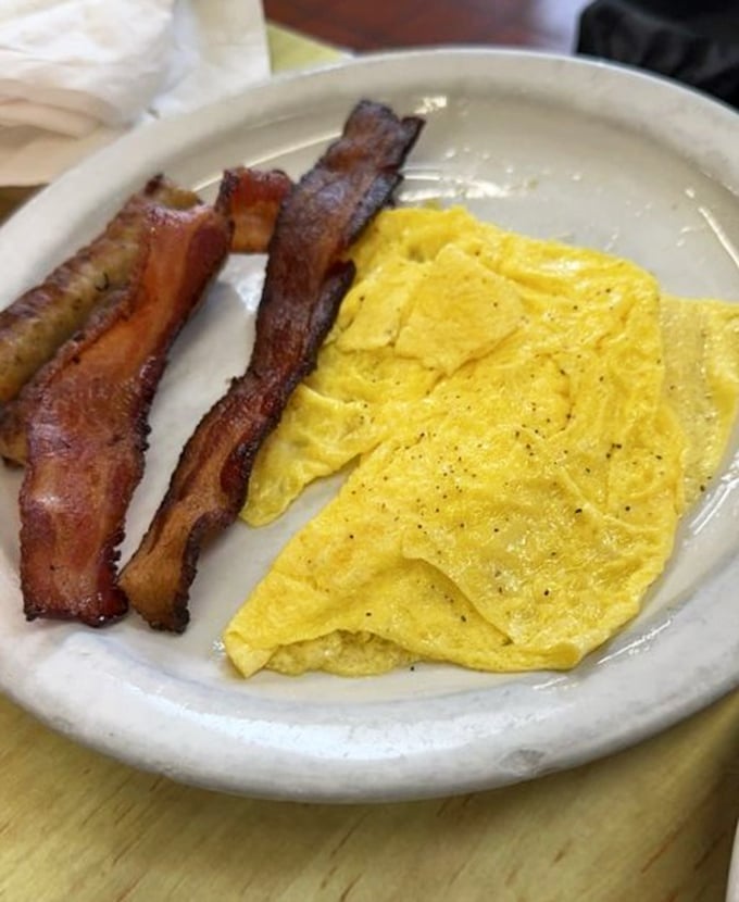 The breakfast power couple that never disappoints&mdash;crispy bacon and fluffy scrambled eggs in perfect harmony on a no-nonsense white plate.