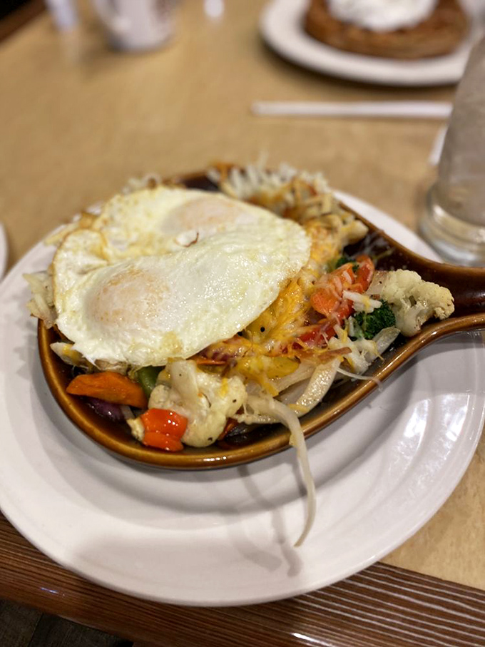 A sunny-side-up egg crowns this vegetable medley like a breakfast tiara, proving healthy choices can still be royally delicious.