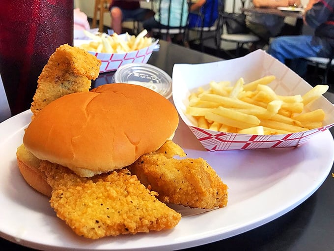 The fish sandwich that could convert seafood skeptics. Crispy, golden-brown perfection nestled in a soft bun with fries standing at attention nearby.