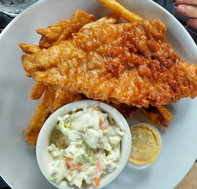 Fish and chips that would make British pubs jealous. Golden-battered perfection with creamy slaw—no passport required for this English classic.