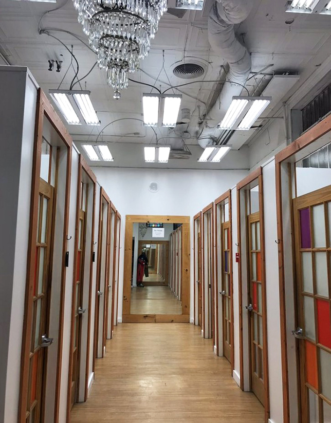 The fitting room hallway, complete with an unexpected chandelier, adds a touch of unexpected glamour to the thrifting experience.