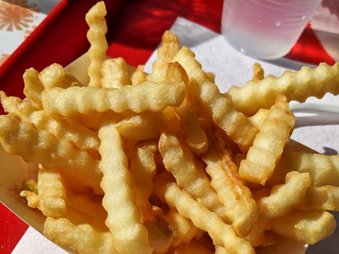 Crinkle-cut fries that achieve the impossible: crispy exterior, fluffy interior, and enough structural integrity to support a generous dip.