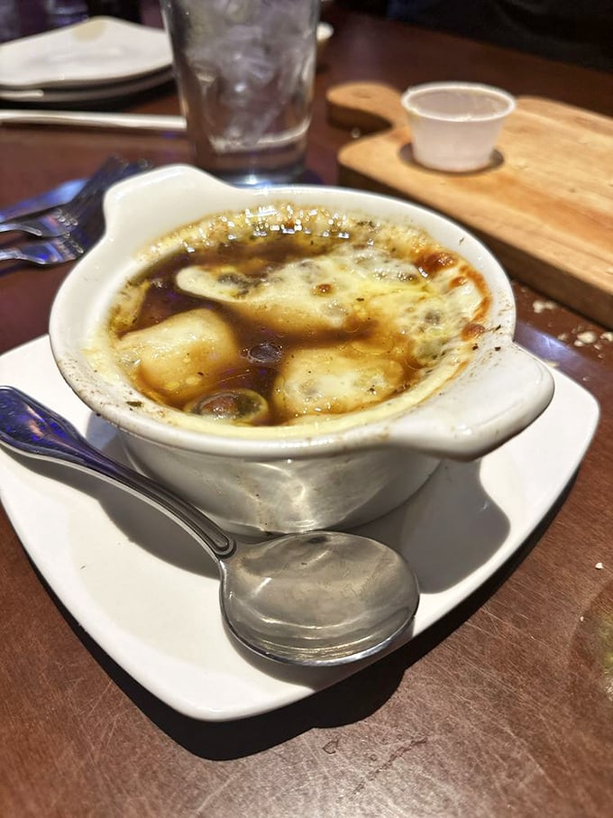 The French onion soup arrives bubbling with melted cheese like a warm, savory blanket&mdash;comfort food that elevates the entire steakhouse experience.