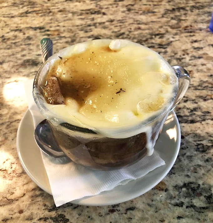 French onion soup with cheese cascading over the edges&mdash;comfort food that makes you forget what meal you're eating.