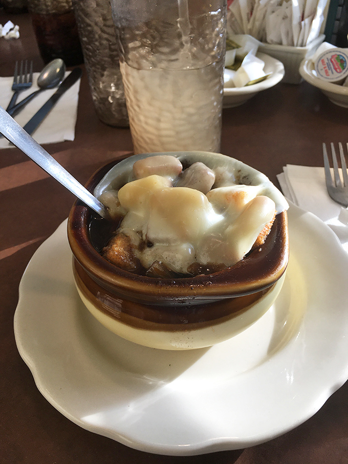 French onion soup that's worth the cheese pull photo opportunity. Beneath that melted canopy lies a broth so rich it could buy a summer home.
