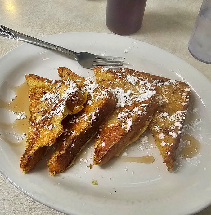 French toast dusted with powdered sugar and swimming in syrup, exactly as the breakfast gods intended it.