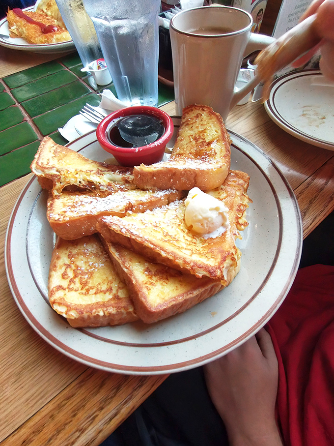 French toast that makes ordinary bread feel inadequate. Perfectly golden, dusted with powdered sugar, and ready for its maple syrup waterfall.
