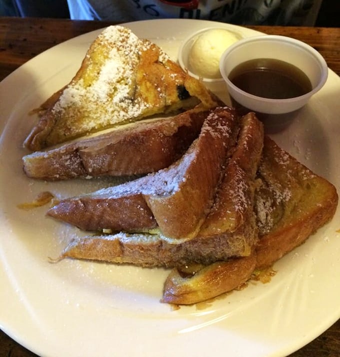 French toast that's dressed for success &ndash; powdered sugar snowfall, golden-brown perfection, and a side of syrup that's begging to create breakfast magic.