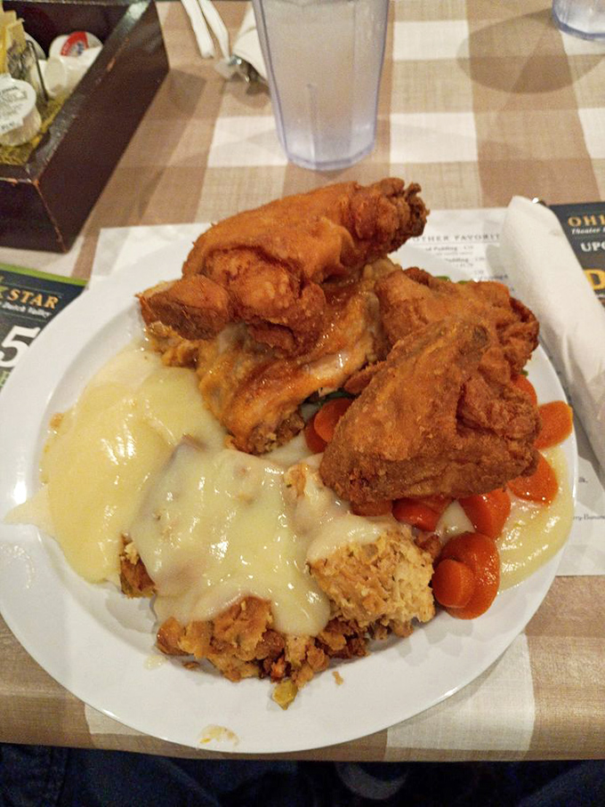 Comfort food heaven: golden fried chicken served with creamy mashed potatoes, savory gravy, and bright carrots on classic checkered tablecloths.