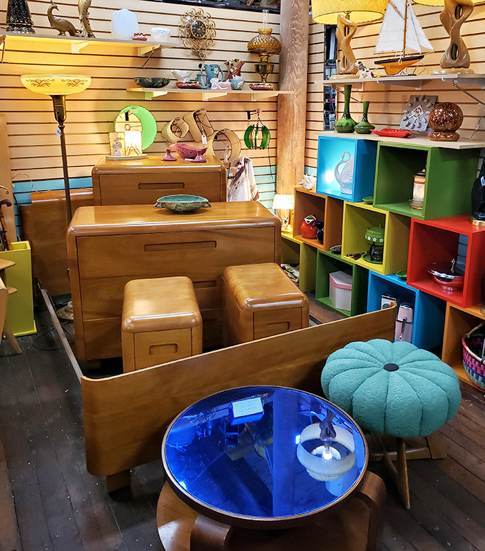 Mid-century modern meets coastal cool in this furniture vignette where blonde wood, vibrant colors, and nautical accents create the perfect retro room.