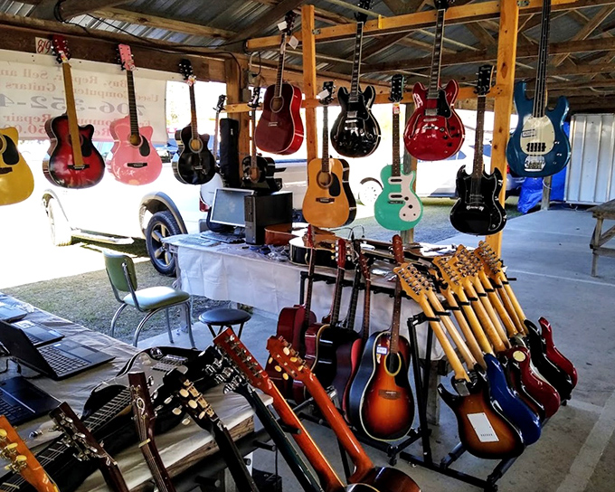 At this musical corner, guitars hang like ripening fruit, waiting for the right hands to pluck them into their second act.