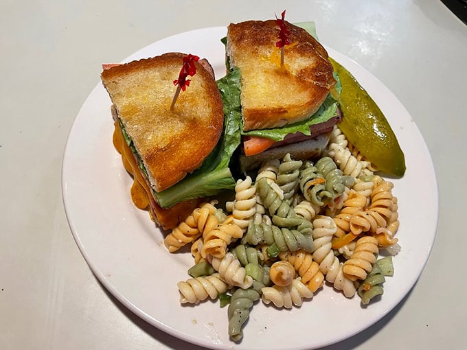 A sandwich built for serious appetites, flanked by tri-color pasta salad that brings a touch of brightness to the hearty proceedings.