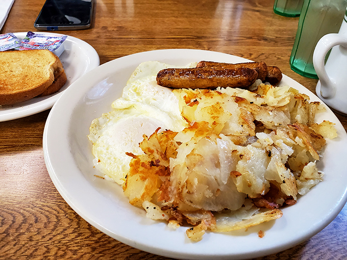 Breakfast perfection: eggs, crispy potatoes, and sausage forming the holy trinity of morning satisfaction that puts cereal to shame.