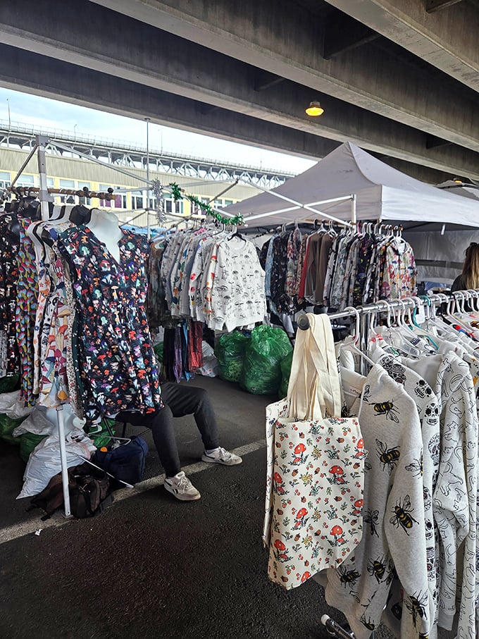 Under the bridge, a clothing vendor creates an impromptu boutique where vintage treasures await their second life with new owners.
