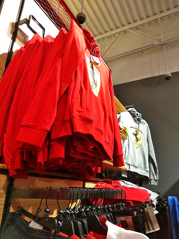 Ferrari-red sweatshirts hang like trophies waiting to be claimed. The thrill of the hunt is almost as satisfying as the savings.