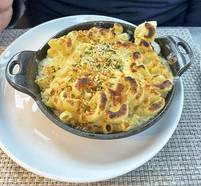 Mac & cheese that's had a glow-up&mdash;bubbling with multiple cheeses in its own cast iron skillet, crowned with a golden-brown crust that audibly crackles when your fork breaks through.