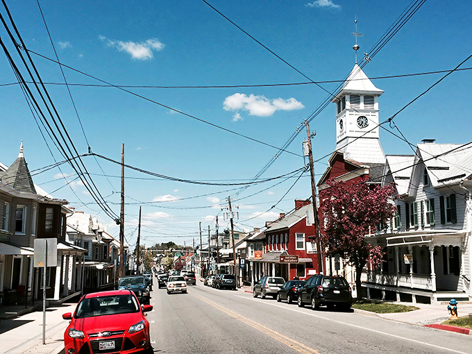 The town's iconic clock tower keeps watch over Main Street, where power lines crisscross the sky like notes on sheet music for a small-town symphony.