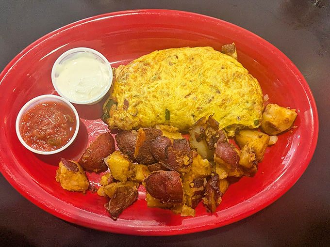 An omelet that refuses to be basic, partnering with home fries that have achieved that mythical crispy-outside, fluffy-inside perfection.