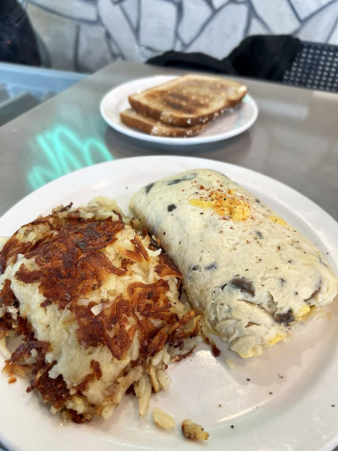 A study in breakfast architecture: golden hash browns with structural integrity and an omelet that's both fluffy and substantial. Toast triangles complete the morning trifecta.