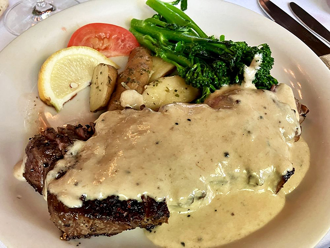 This isn't just steak&mdash;it's a carnivore's dream draped in velvety sauce with perfectly roasted potatoes and vibrant broccolini standing guard.