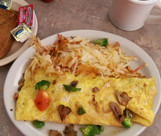 This isn't just an omelet&mdash;it's breakfast architecture. Perfectly folded eggs housing a garden of vegetables with a crown of golden hash browns. 