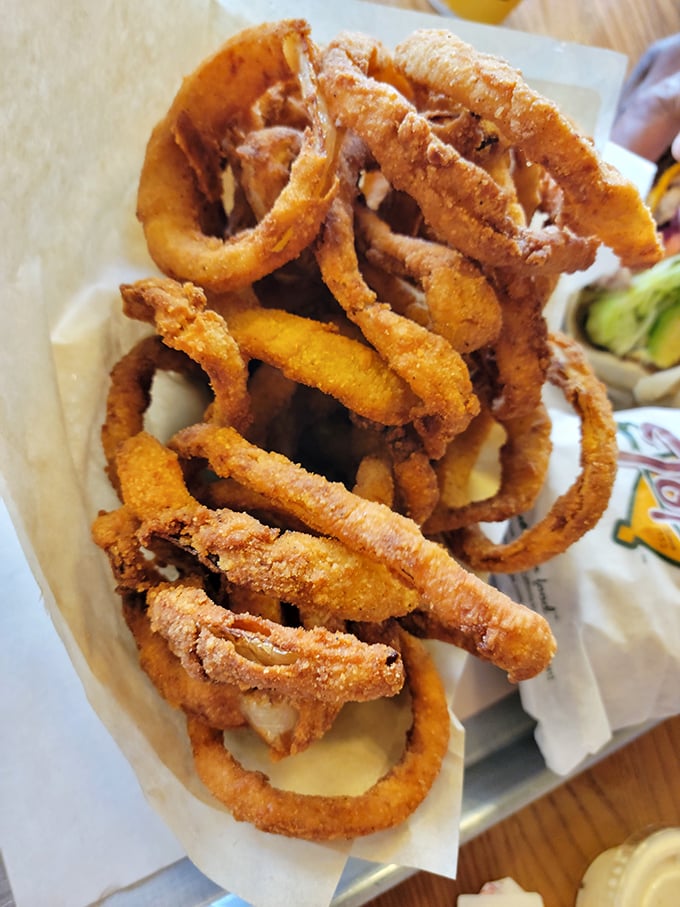 Onion rings stacked like delicious golden halos. Crispy, substantial, and demanding respect that those frozen imposters never earn.