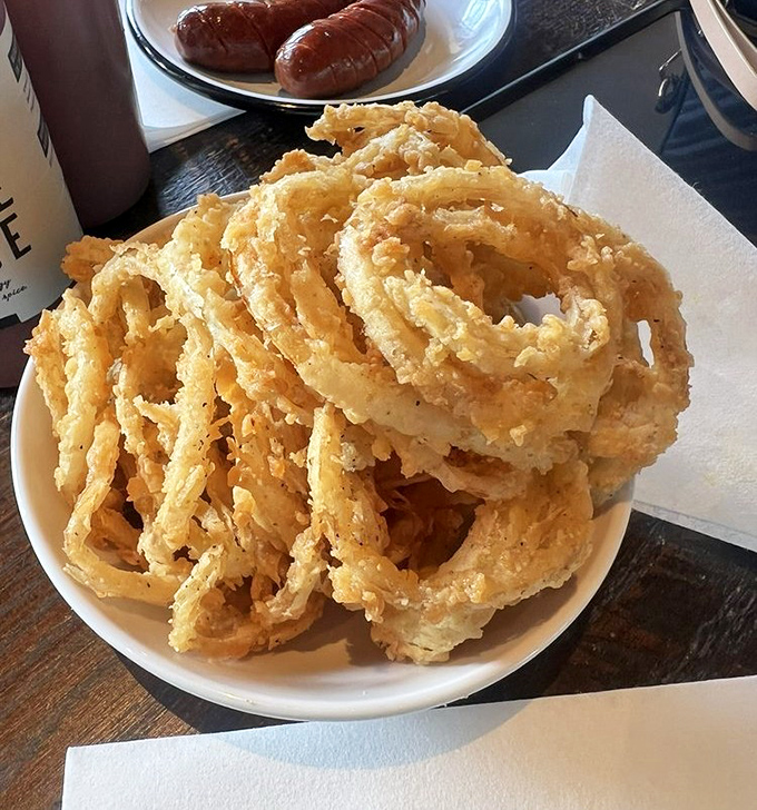 Onion rings stacked higher than your weekend ambitions&mdash;crispy, golden halos that make you wonder why anyone bothers with lesser side dishes.