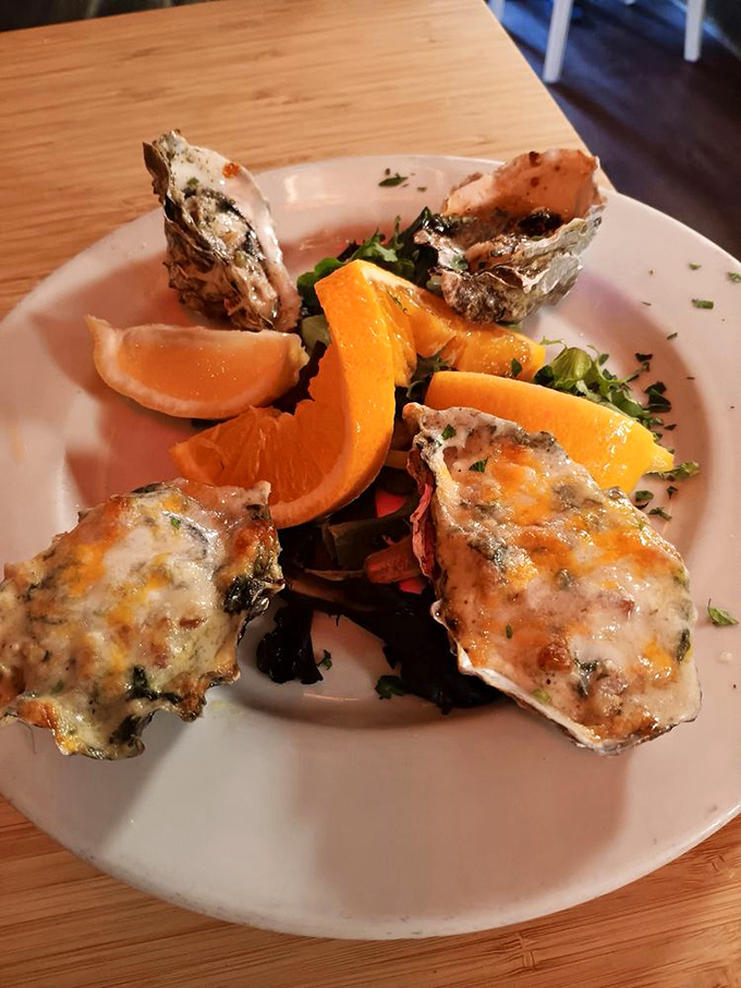 Oysters that taste like they were harvested minutes ago, topped with melted cheese and served with citrus that brightens every briny bite.