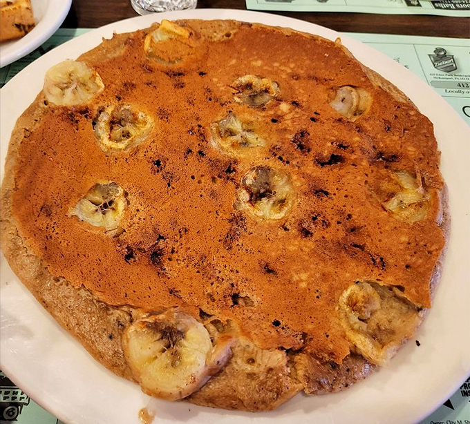 This isn't just any pancake &ndash; it's a golden-brown canvas dotted with caramelized bananas, the kind of breakfast that makes you reconsider your relationship with cereal.