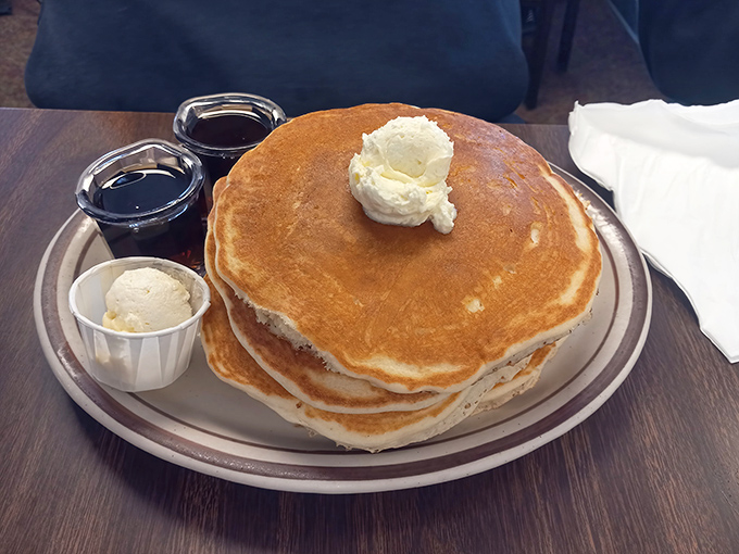 Pancakes stacked higher than my expectations, with butter melting like a golden crown. Maple syrup stands ready for its grand entrance.