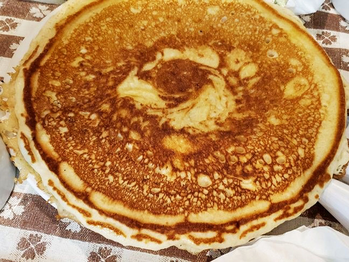 This isn't just any pancake&mdash;it's the golden-brown canvas of breakfast dreams, perfectly sized to cover the plate like a delicious security blanket.