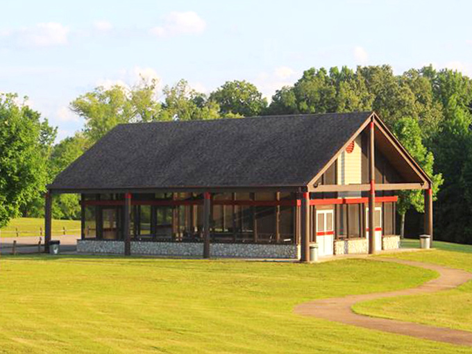 The park's pavilion stands ready for gatherings, its rustic charm complemented by an emerald lawn that practically begs for a picnic.
