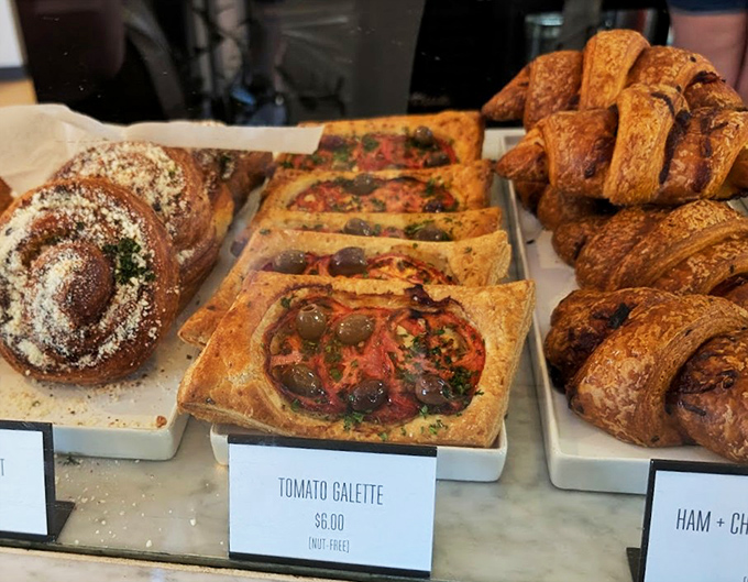 The pastry trifecta: cinnamon swirls, savory tomato galettes, and croissants that would make a Parisian weep with joy.