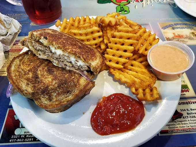 This patty melt represents the pinnacle of sandwich engineering &ndash; crispy grilled bread, melted cheese, and seasoned beef with waffle fries standing guard.