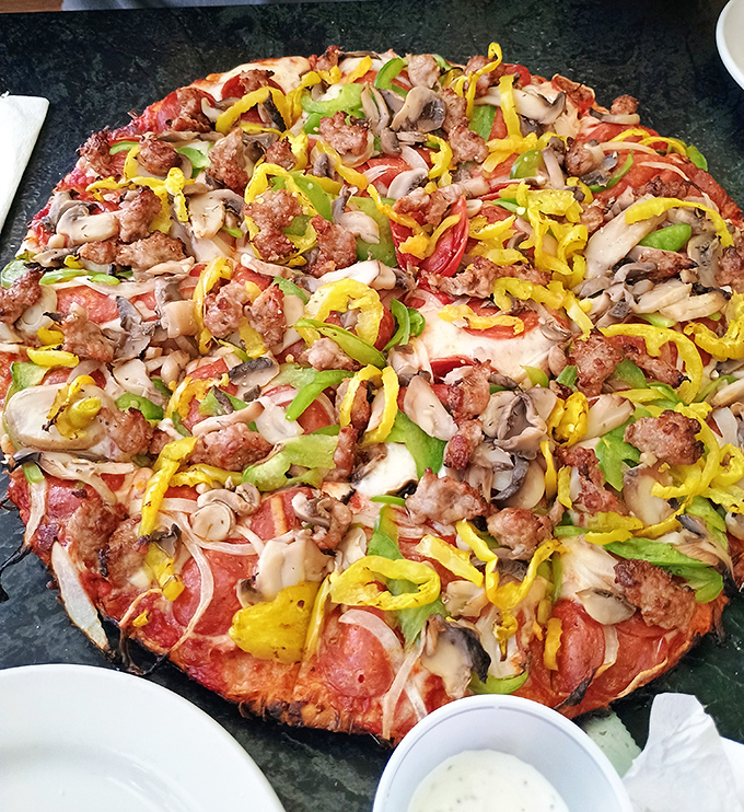 A pizza masterpiece in the making! Colorful toppings create an edible mosaic of flavors&mdash;sausage, peppers, and mushrooms playing together in perfect harmony.