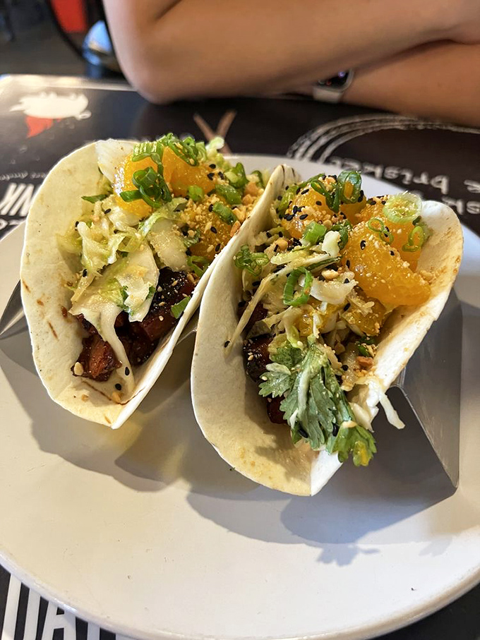 Soft flour tortillas cradle smoky pork belly topped with fresh herbs&mdash;where Mexico meets the American South brilliantly.