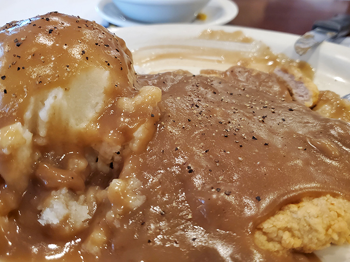 Country gravy cascading over golden-brown pork tenderloin&mdash;a Midwestern masterpiece that turns a simple plate into a canvas of comfort.