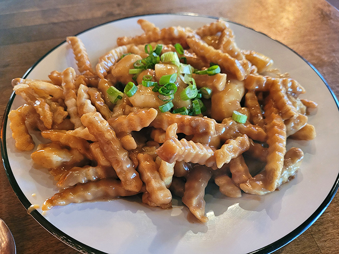 Crispy fries swimming in savory gravy and topped with green onions&mdash;poutine that would make even Canadians nod in approval.