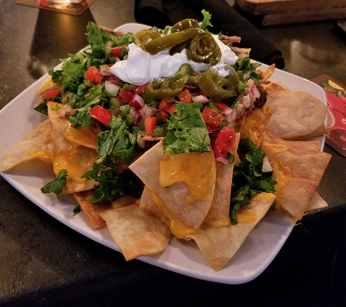 Nachos that require a strategy to eat. Each chip is like a little treasure chest loaded with pulled pork, cheese, and the promise of napkin dependency.