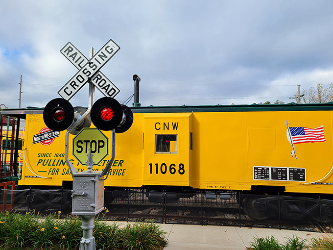 This railroad crossing signal stands as a nostalgic sentinel, its red lights and distinctive "X" a universal symbol of childhood wonder.