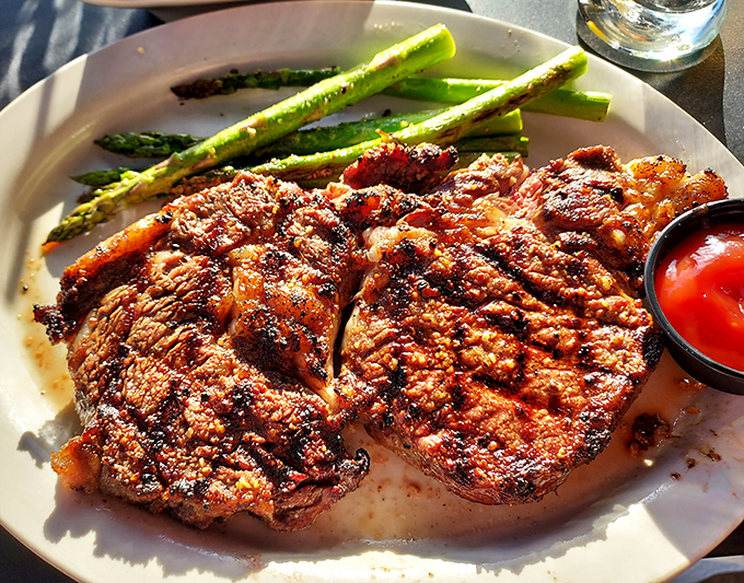 Two ribeyes that have clearly been introduced to fire at exactly the right moment, accompanied by asparagus spears standing at attention like delicious green soldiers.
