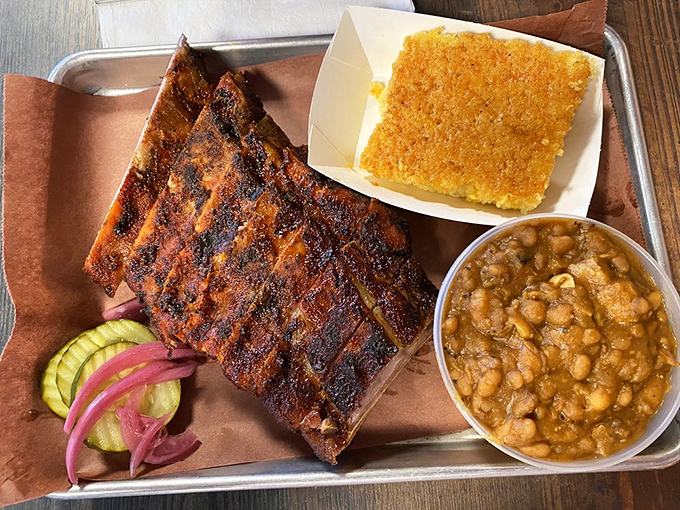 These ribs arrive with a mahogany bark that practically glows, accompanied by classic sides that complete the smoky symphony.