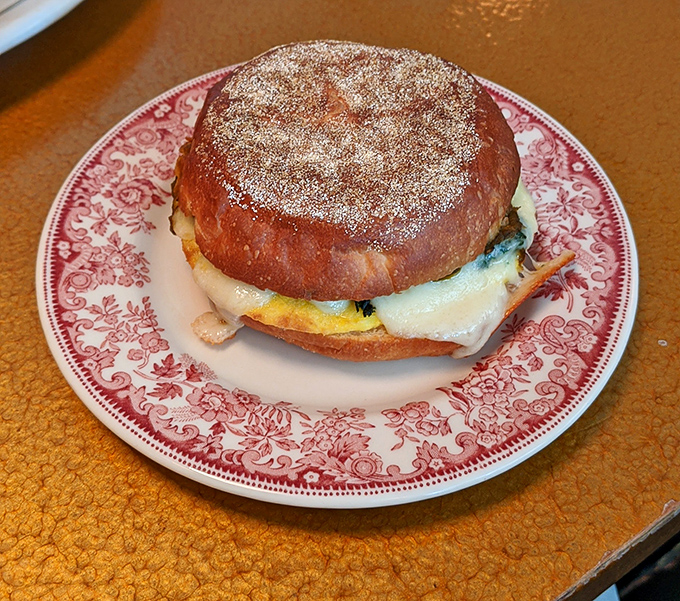 A sandwich cut in half to reveal its secrets&mdash;like a culinary autobiography with chapters of melted cheese and vibrant veggies.